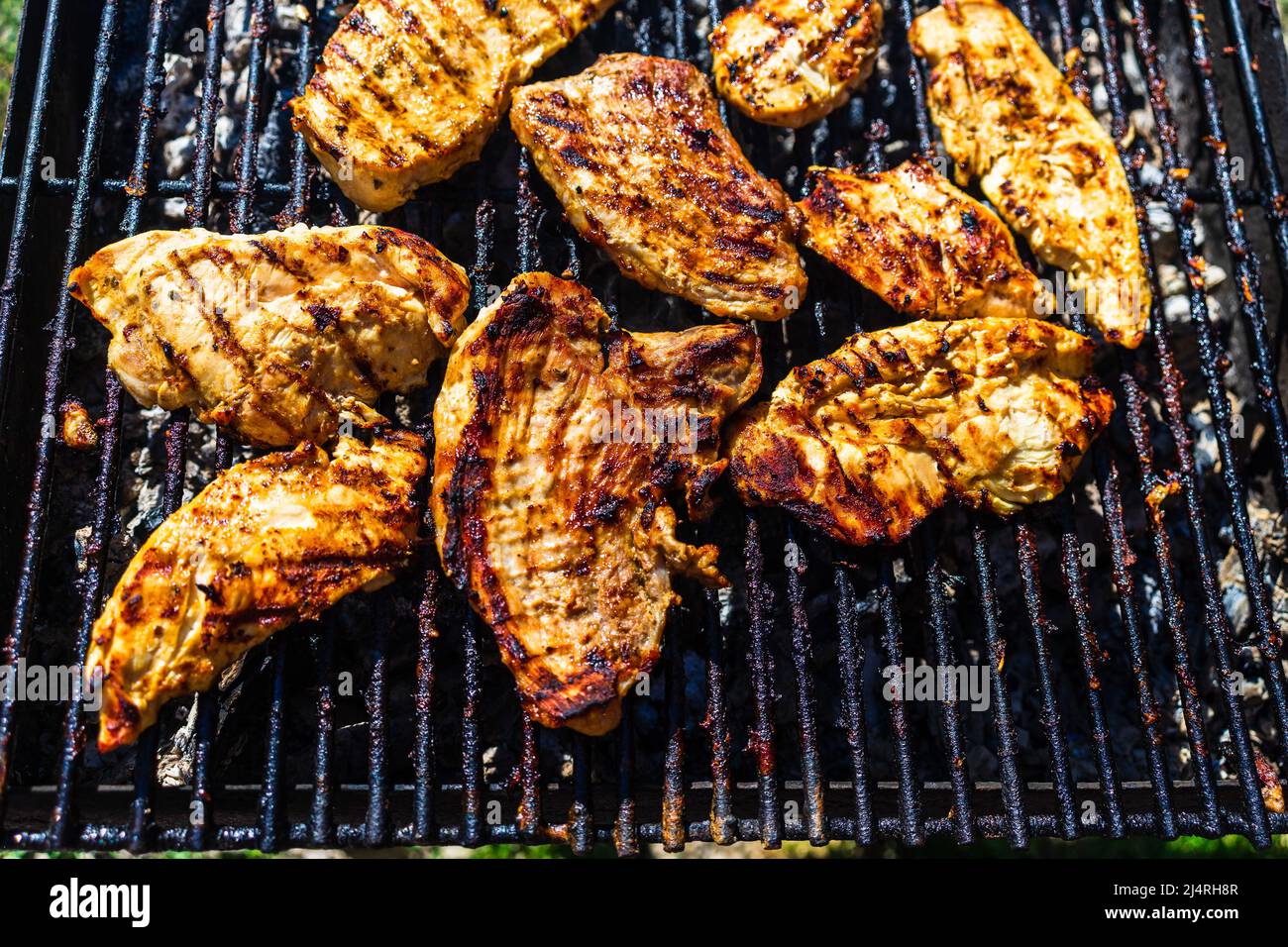 Chicken and pork steak grilled on a charcoal barbeque. Top view of ...