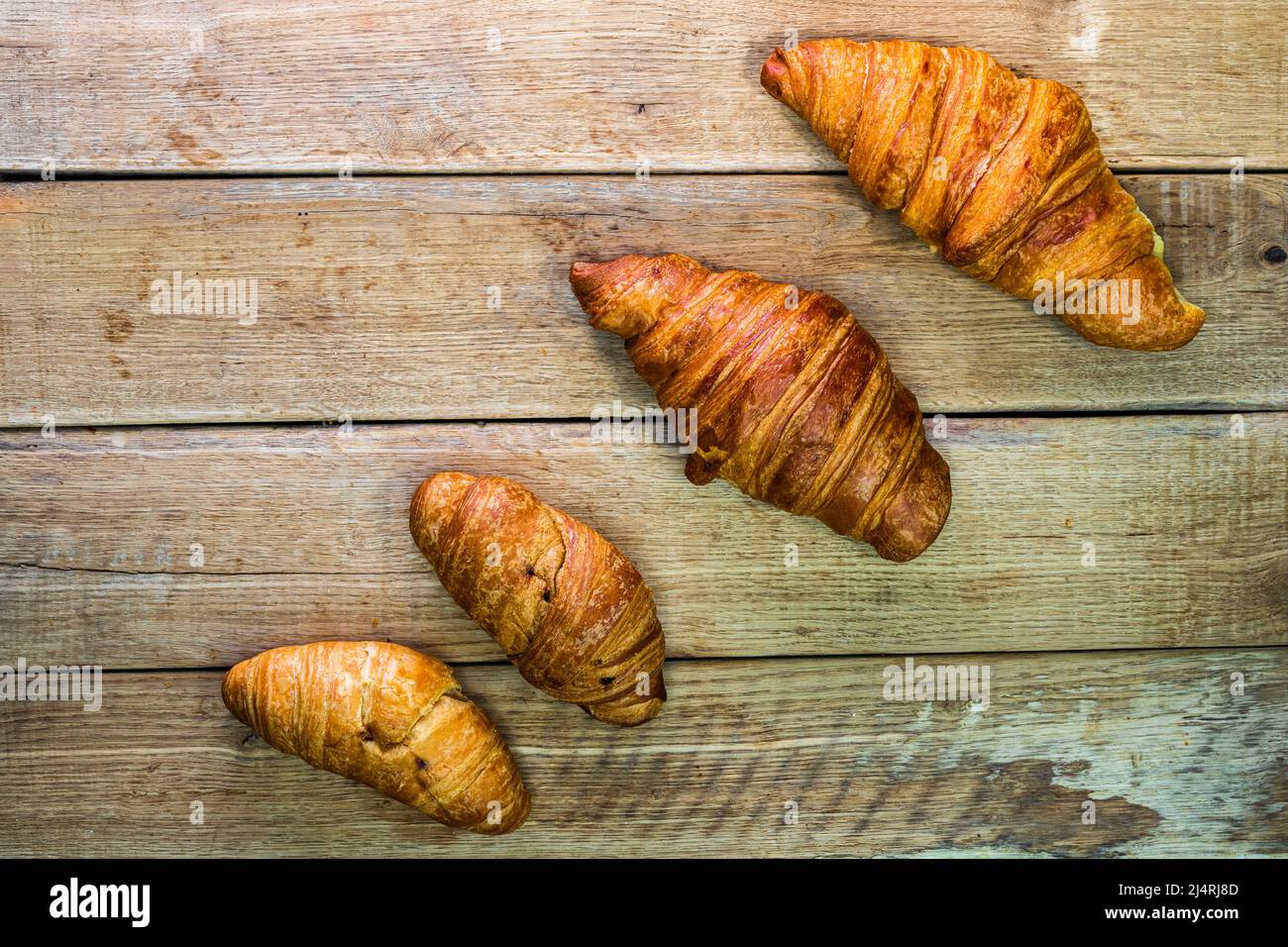 Fresh croissant, puff pastry and biscuits on wooden table. Food and ...