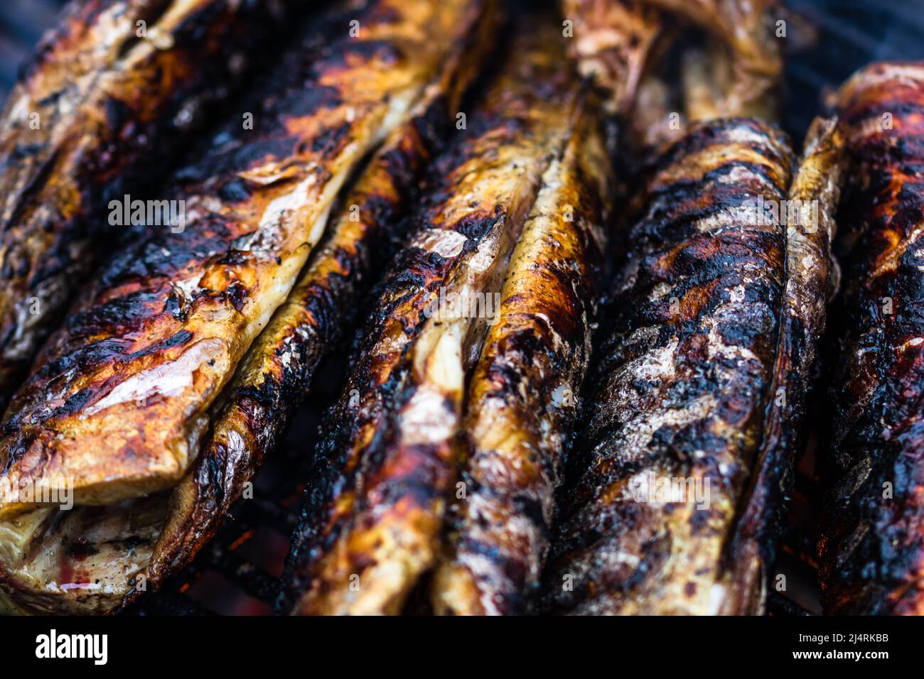 Grilled fish with smoke on a charcoal barbecue. Close up fish on the ...