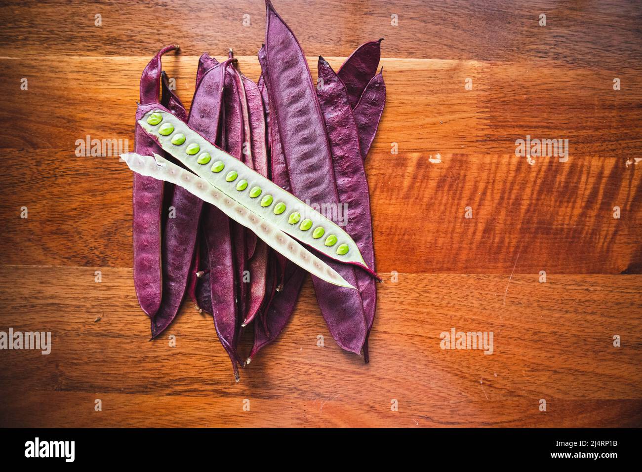 Pile of Guaje seed pods on a wood table with one open seed pod in ...