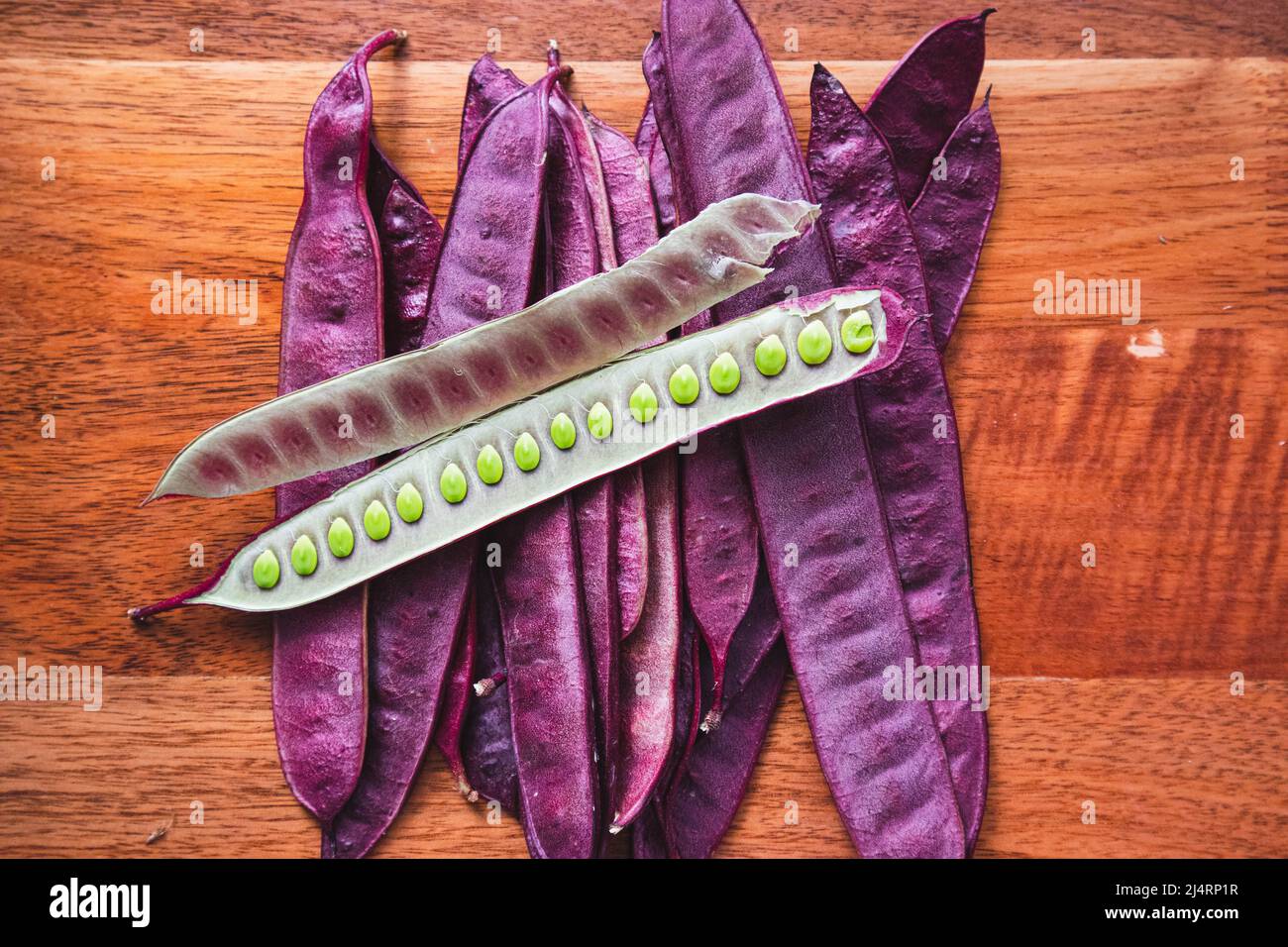 Pile of Guaje seed pods on a wood table with one open seed pod in ...