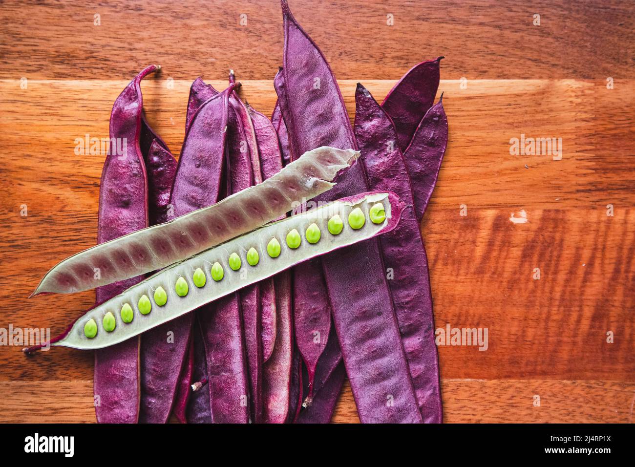 Pile of Guaje seed pods on a wood table with one open seed pod in ...