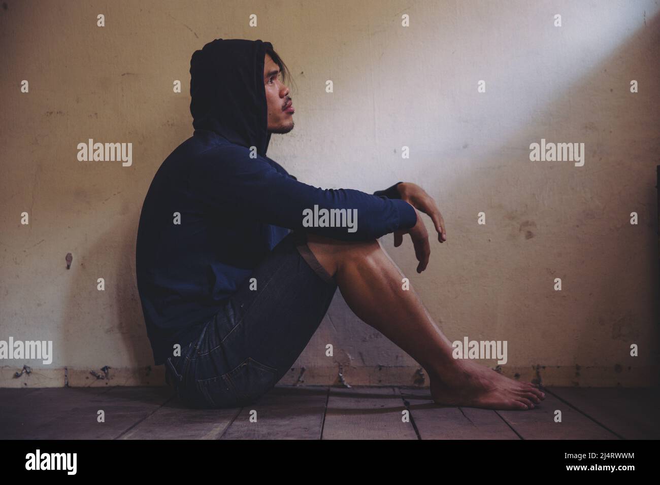 sad man sitting alone in the dark Stock Photo - Alamy