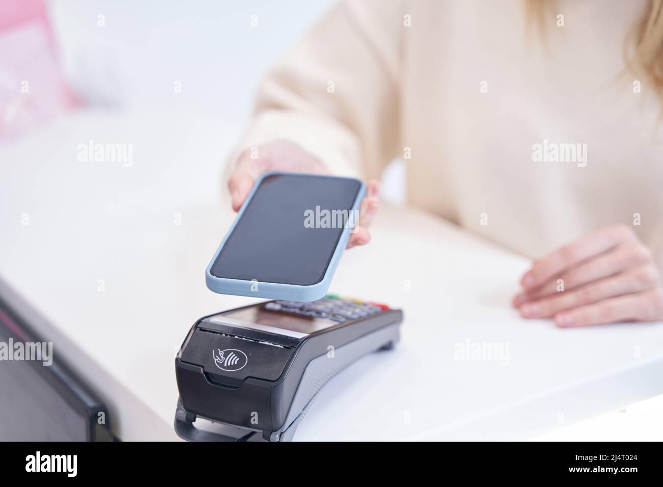 Beauty clinic client making contactless payment at reception desk Stock ...
