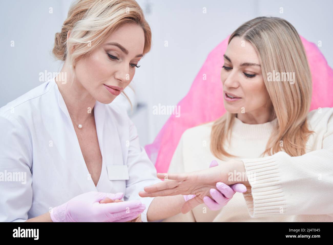 Concentrated professional dermatologist performing cutaneous ...