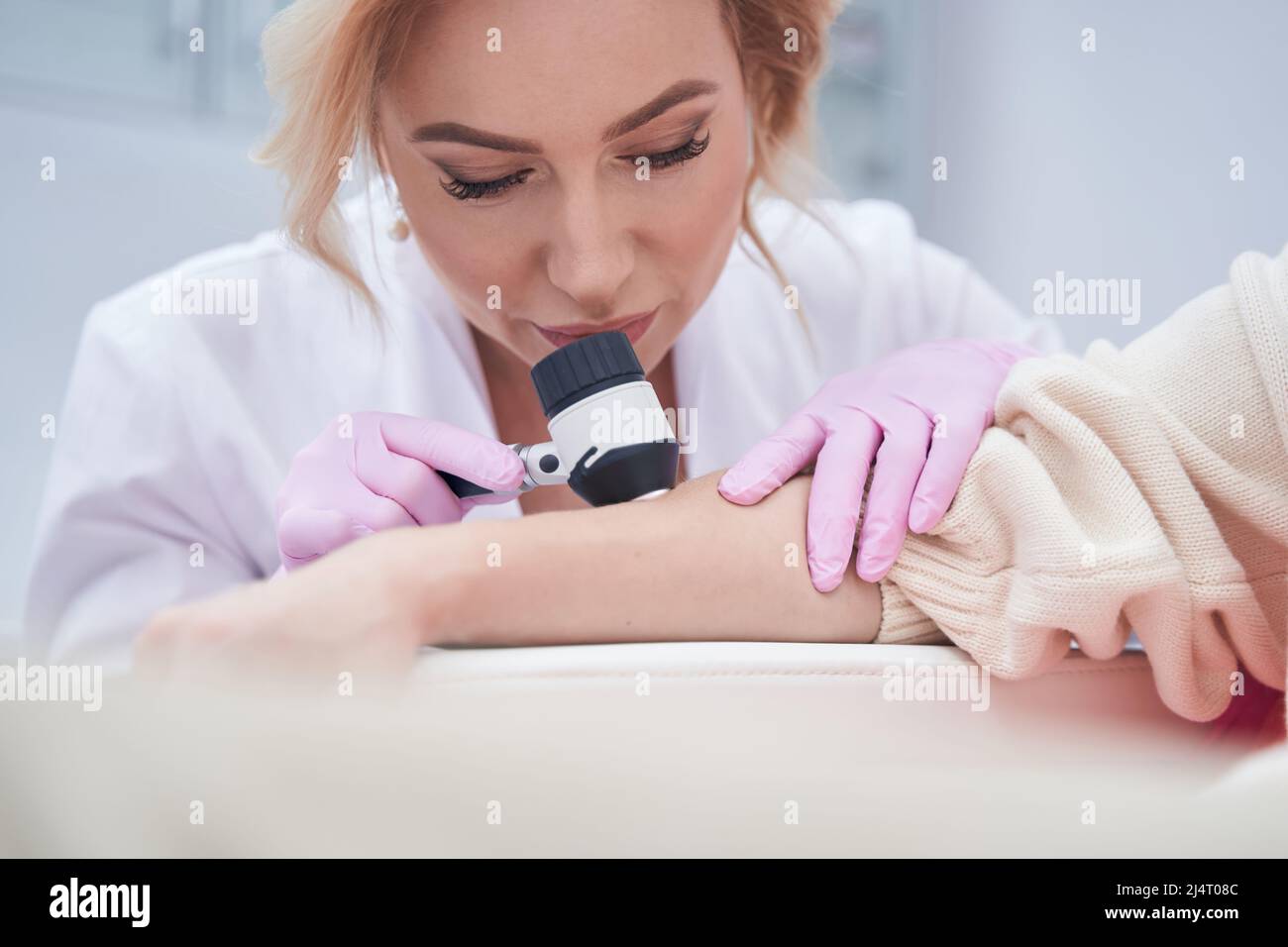 Concentrated dermatologist conducting patient skin check with ...
