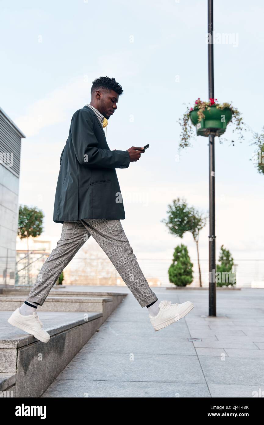 african-american man with smartphone walking without looking where he ...
