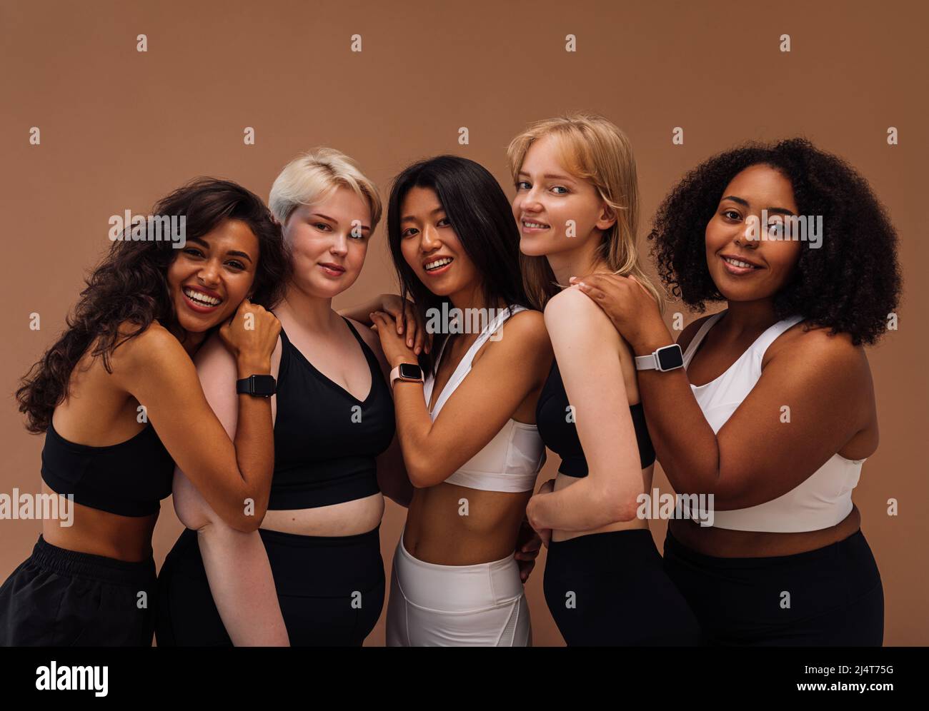Five women of different body types embracing together. Cheerful females ...