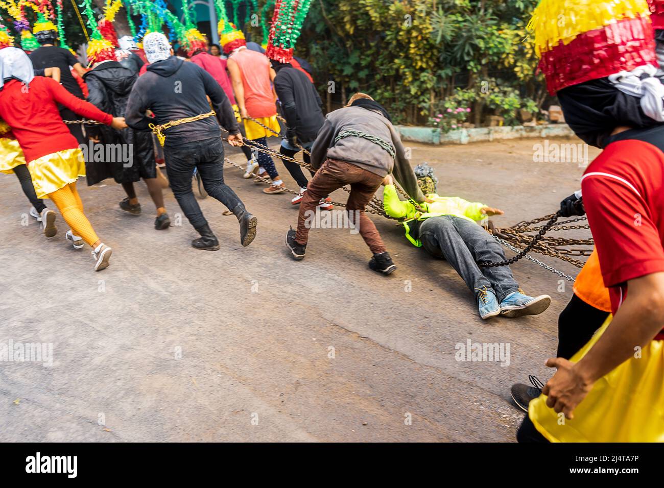 Group of pledgers dragging a chained volunteer along the ground ...