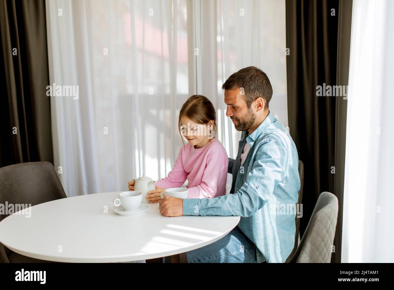 Father and daughter drinking tea together at the living room Stock ...