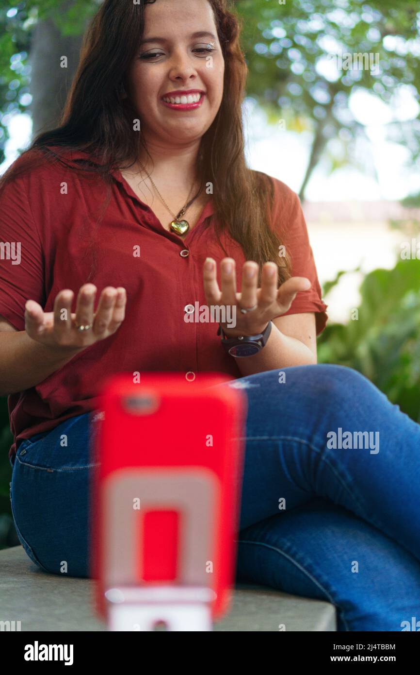 female vlogger recording content for her vlog with a mobile phone while ...