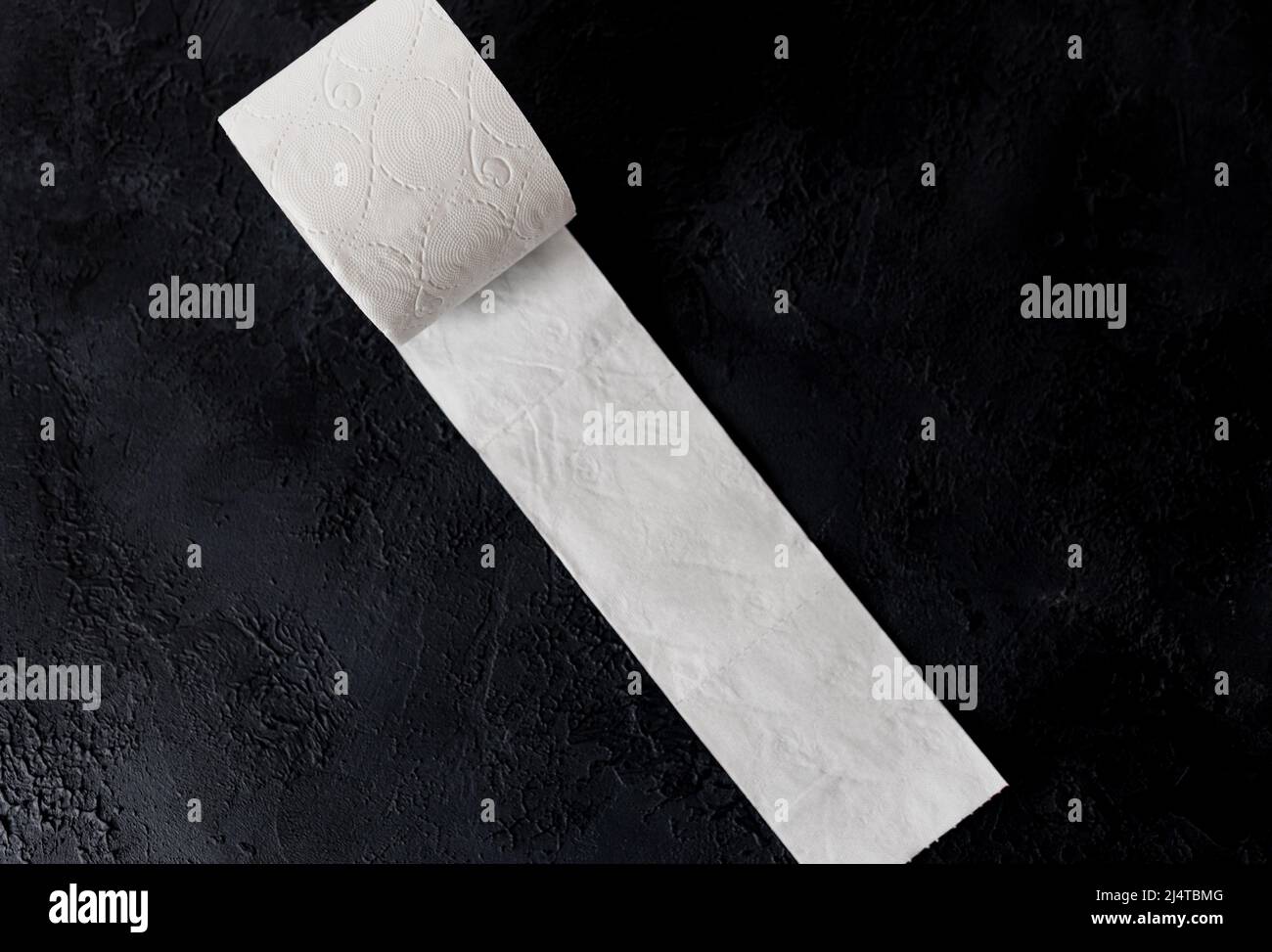 Top view of unrolled toilet paper at black texture background. Tissue ...