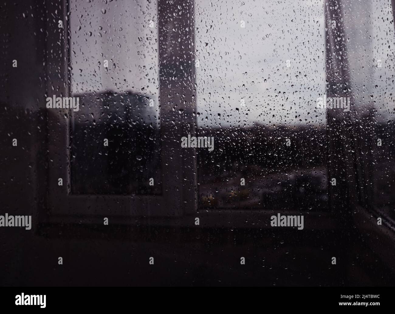 Rainy season. Raindrops on window's glass in a dark weather day ...