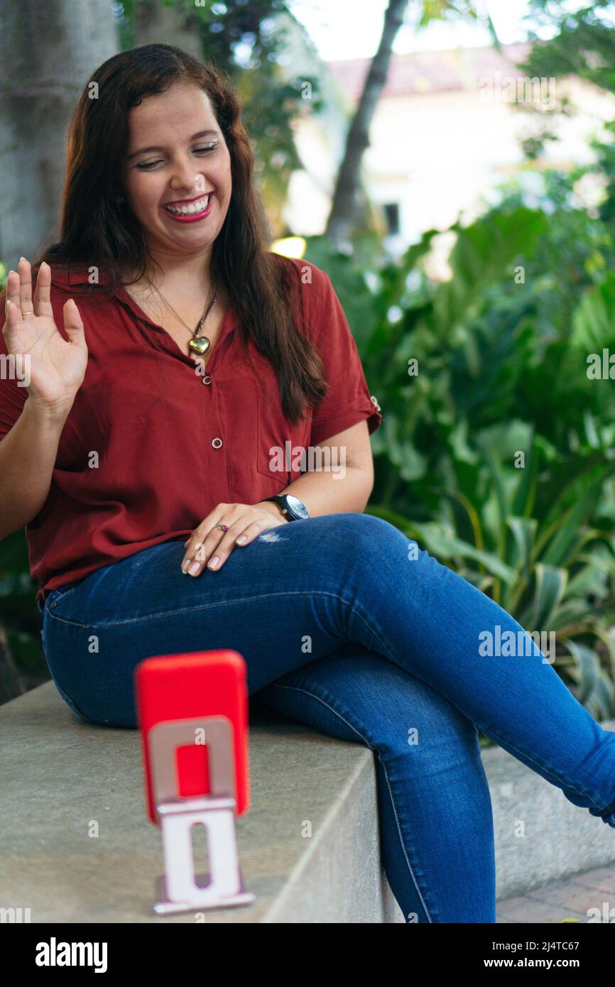 Hispanic female vlogger recording content for her vlog with a mobile ...