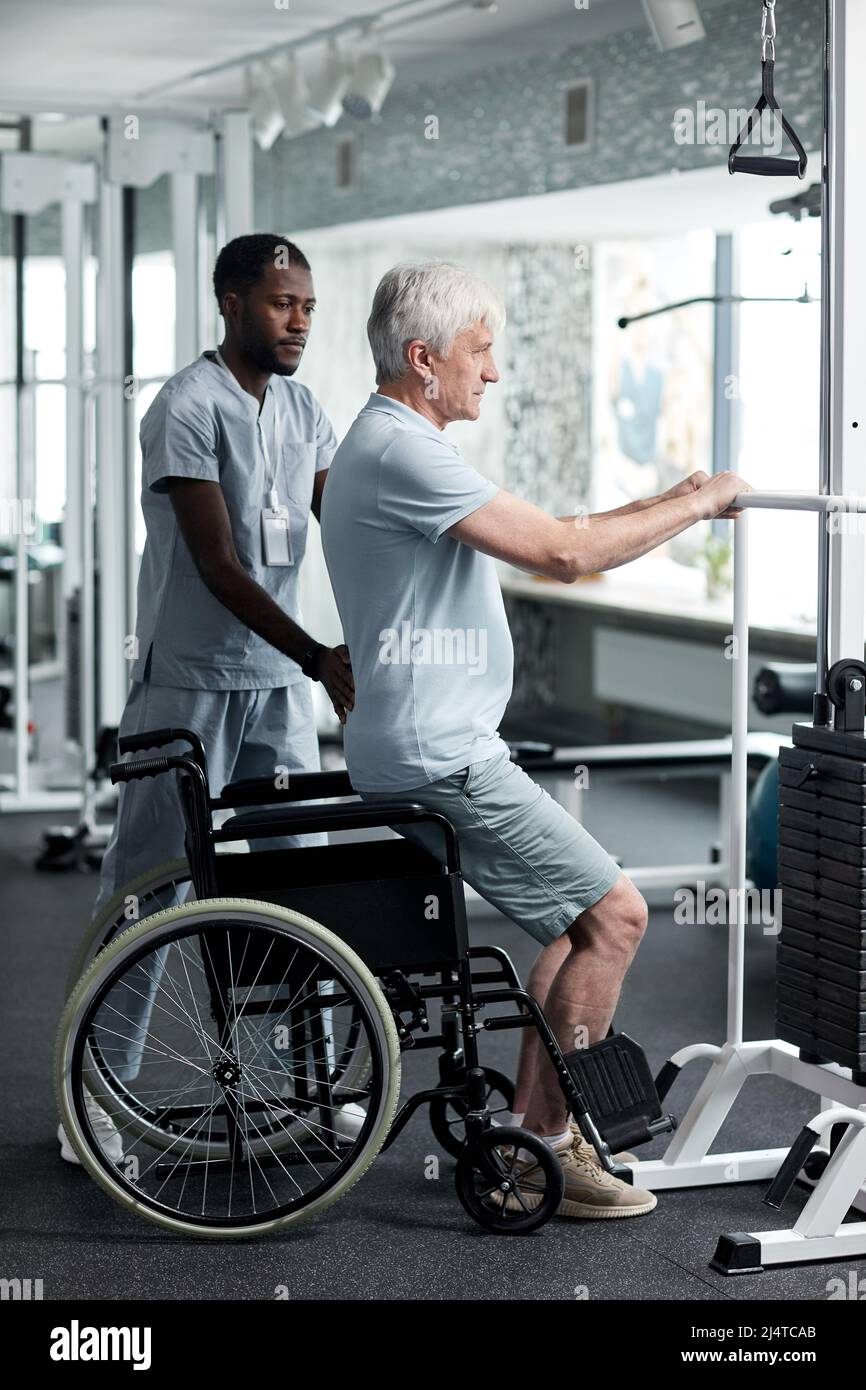 Full length portrait of senior man doing rehabilitation exercises in ...