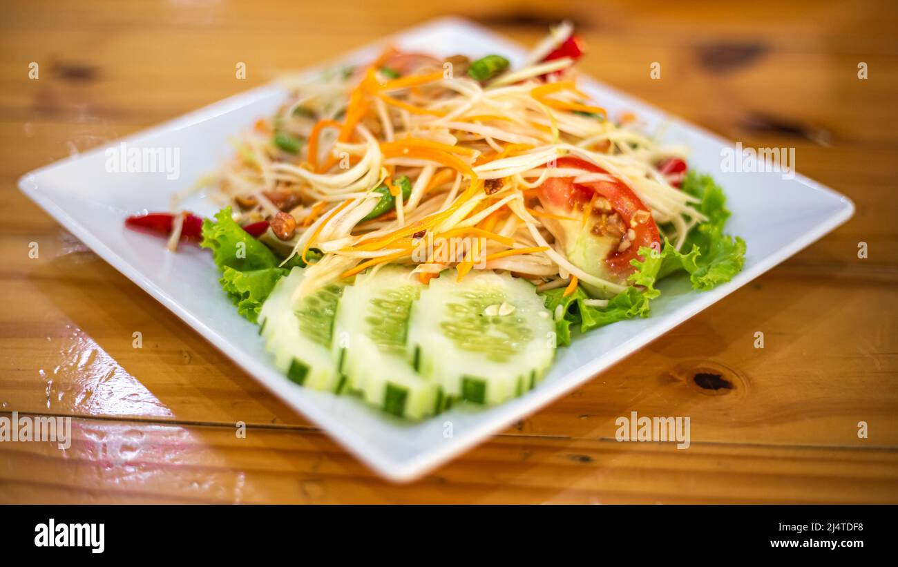 A plate of vegetable Thai papaya salad Som Tam. Remaining Asian cuisine ...