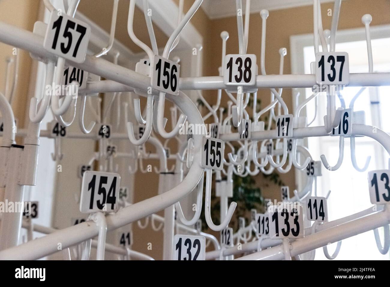 A clothes hanger in the hotel cloakroom. Multiple numbered hangers on ...