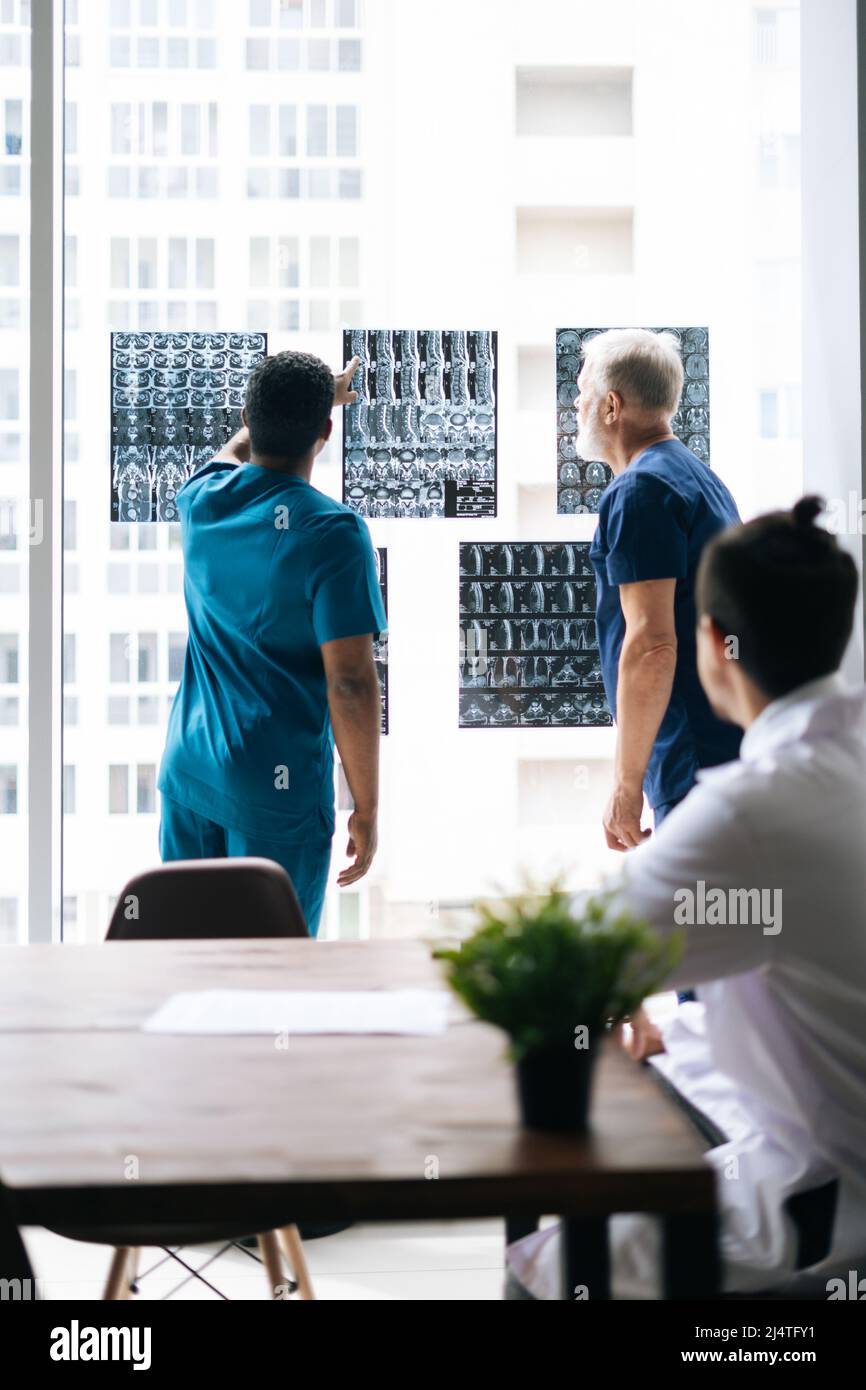 Vertical shot of team focused multiethnic doctors discussing together ...