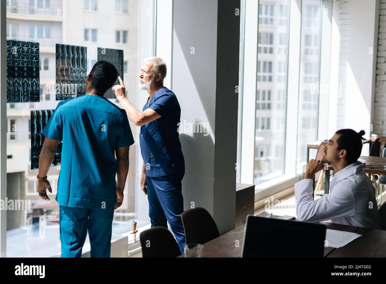 Back view of team multi-ethnic doctors discussing together history ...