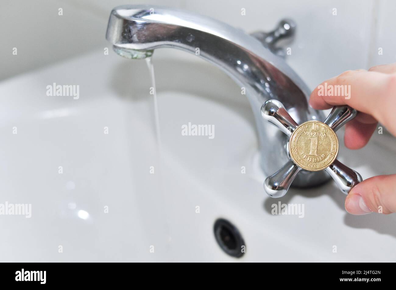 faucets in the bathroom with a Ukrainian hryvnia coin, translation from ...