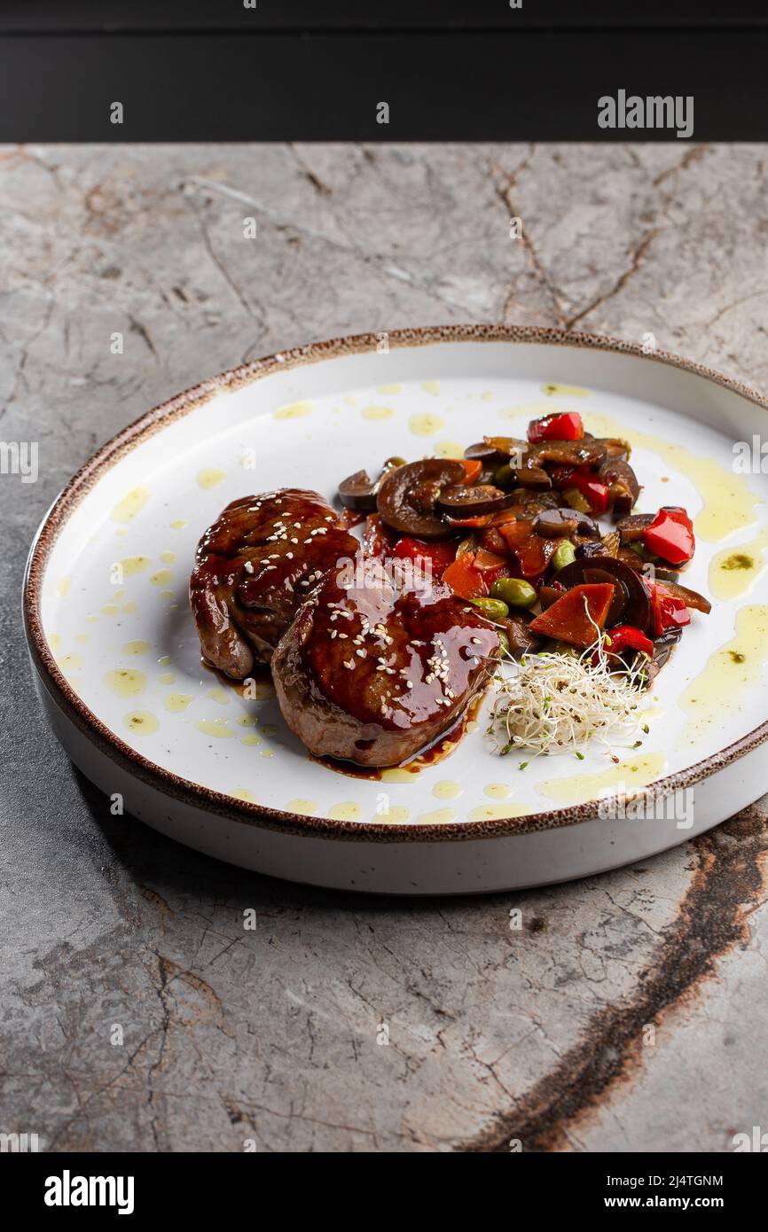 Grilled meat fillet steak wrapped in bacon medallions with raspberry ...