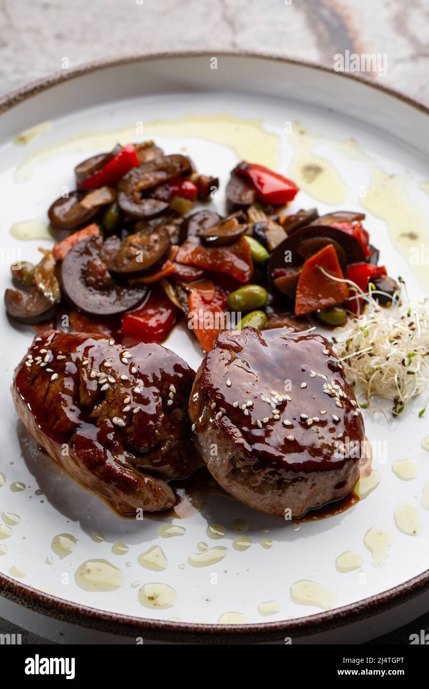 Grilled meat fillet steak wrapped in bacon medallions with raspberry ...