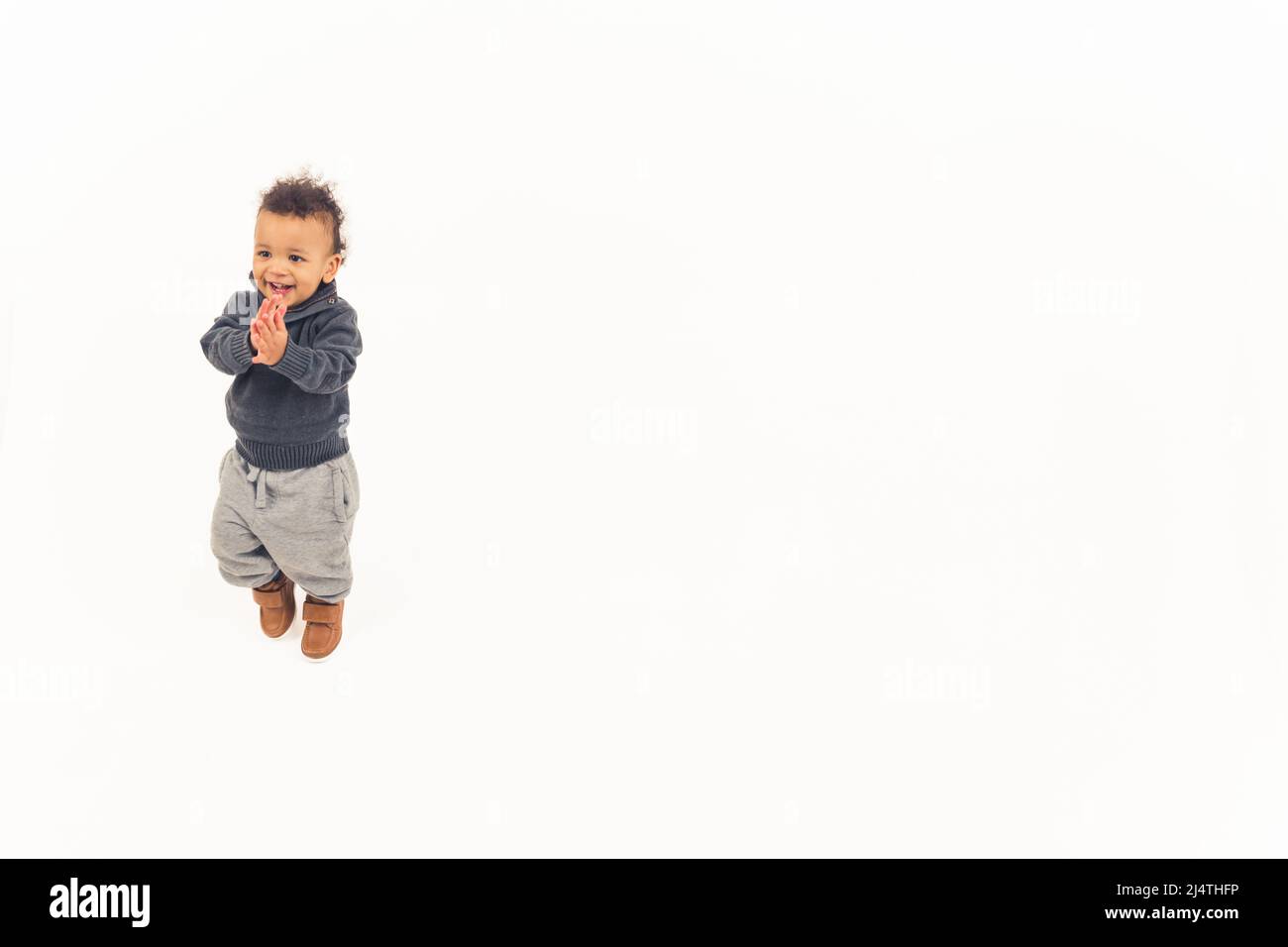 handsome toddler standing on the floor applauding and smiling. High ...