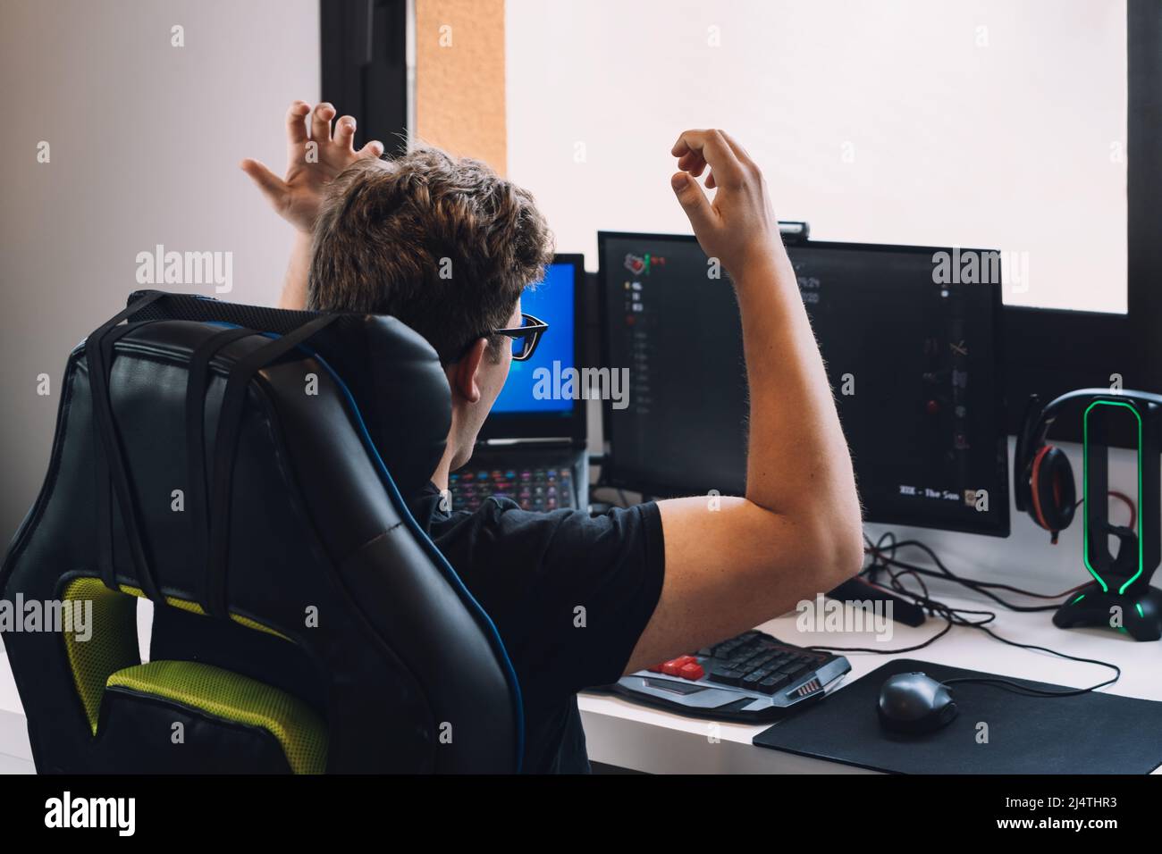 young blond man happily celebrating winning a video game on his ...
