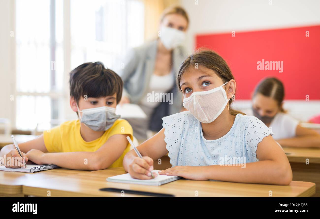 Kid in mask cheating during test Stock Photo - Alamy