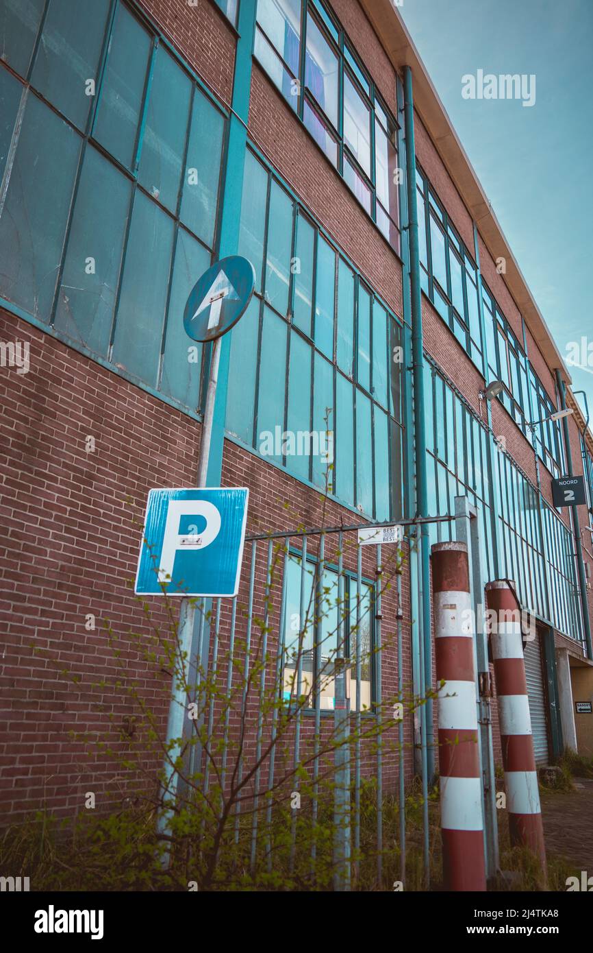 Parking sign in front of an old warehouse Stock Photo - Alamy
