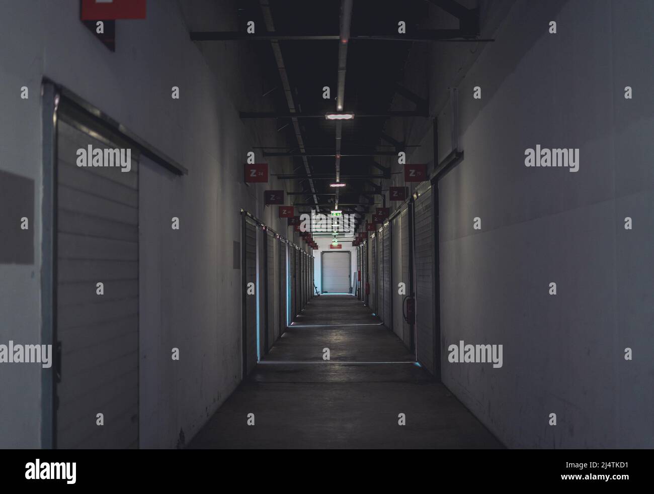 Long dark corridor with doors to storage in a warehouse Stock Photo - Alamy
