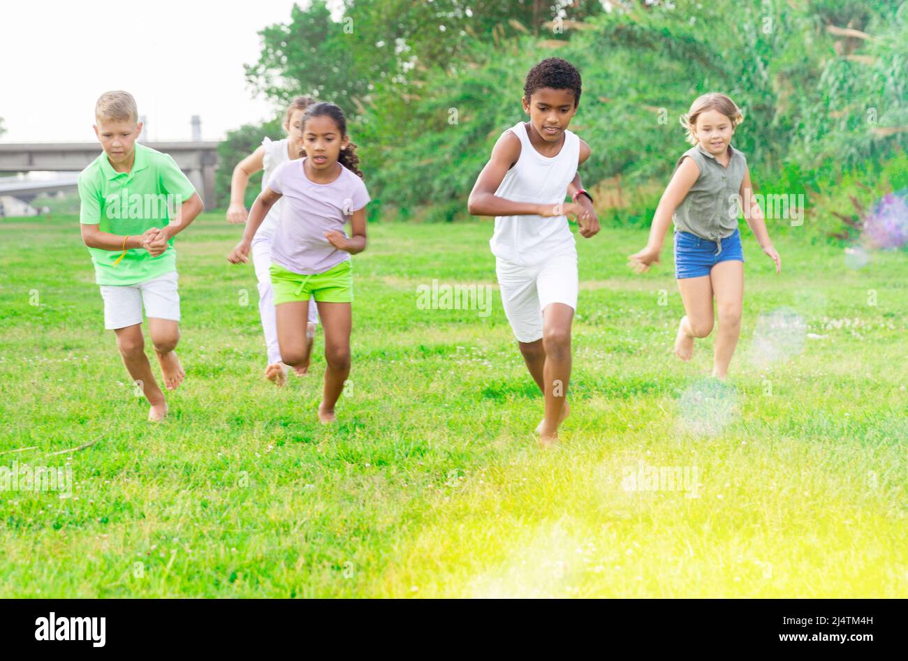 Five smiling kids running and laughing in park Stock Photo - Alamy