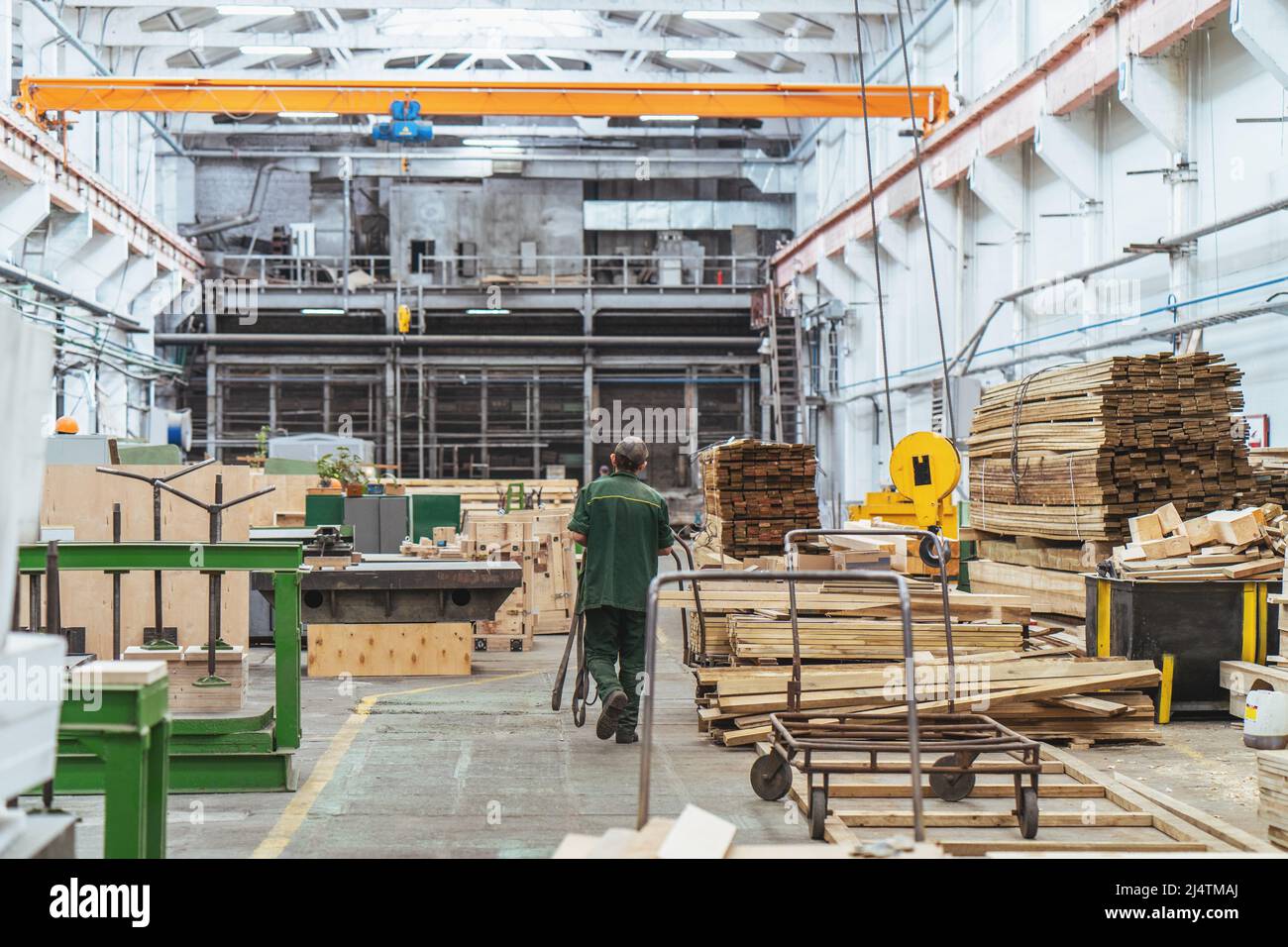 Woodworking worker in factory with stack of wood Stock Photo - Alamy