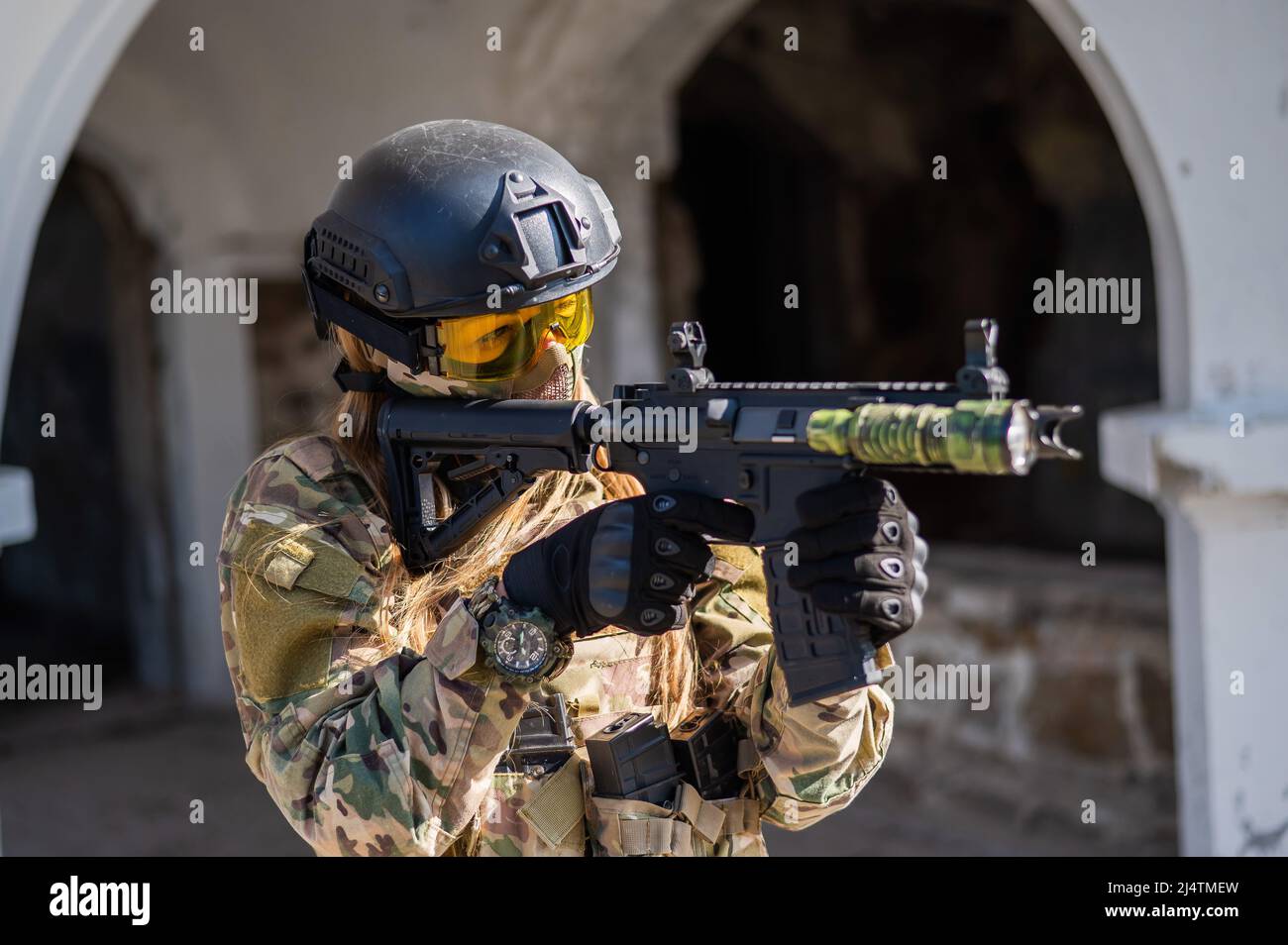 Caucasian woman in a protective suit with a machine gun. A female ...