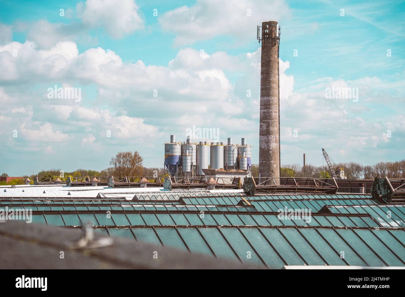 Chimney and silos seen from a factory roof Stock Photo - Alamy