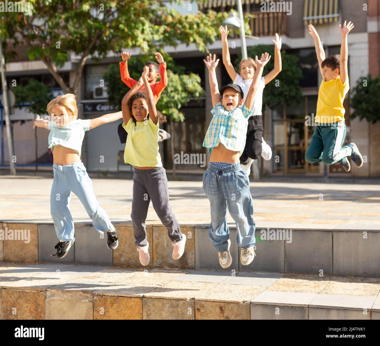 Happy preteen children jumping on city street in summer Stock Photo - Alamy