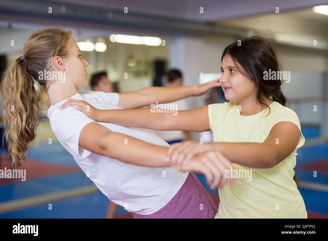 Two girls learn to do a painful hand grip in self-defense lesson Stock ...