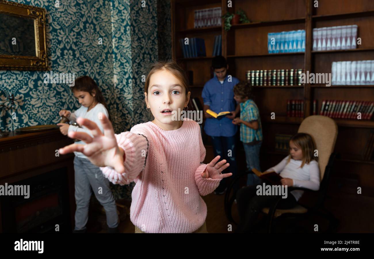 Tween girl trying to reach for something in escape room Stock Photo - Alamy