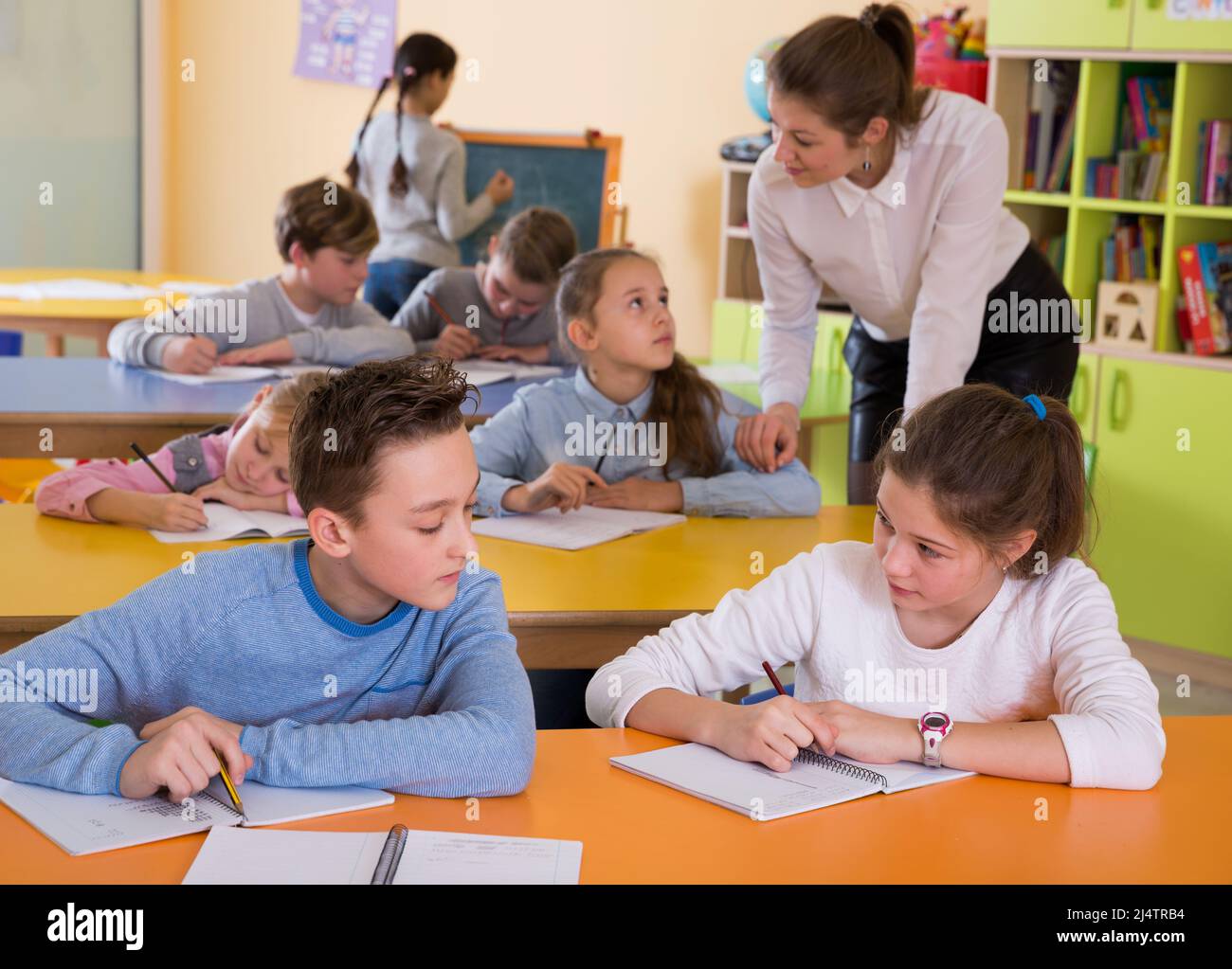 Teacher and pupils working in classroom Stock Photo - Alamy