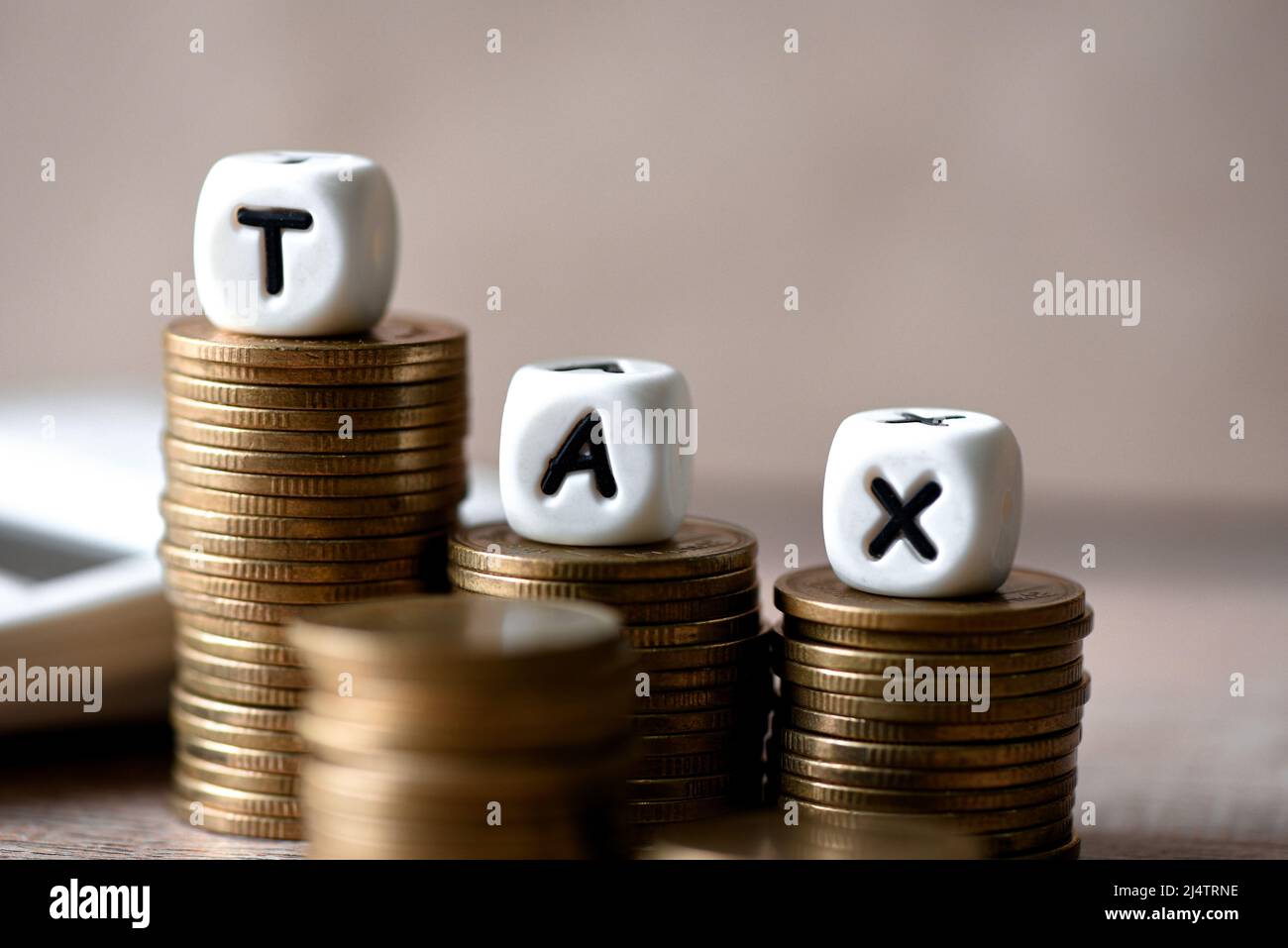 Block word tax on money on wooden background, TAX on stacked coins ...