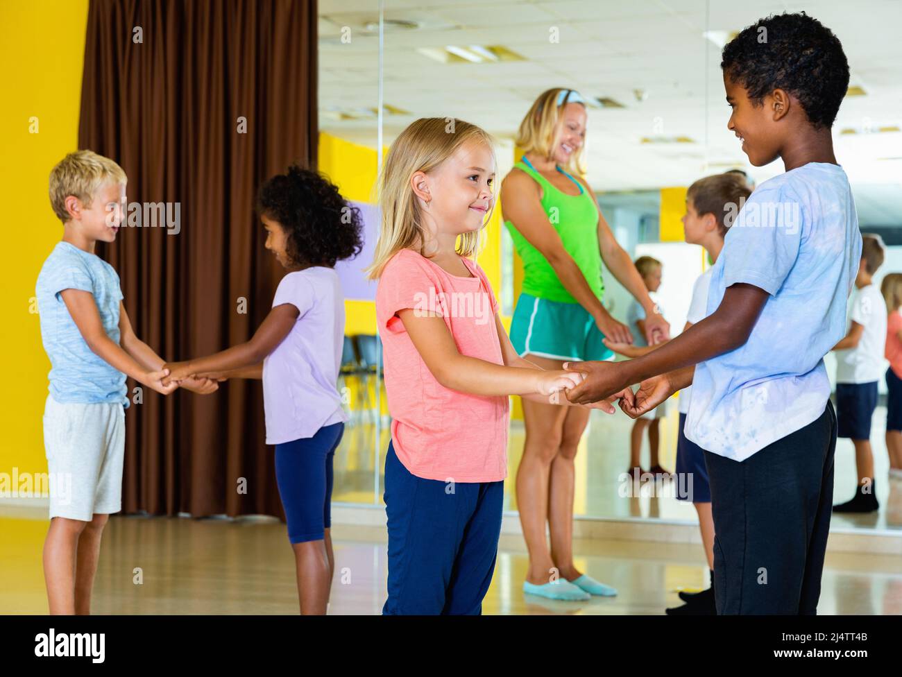 Group of children practicing vigorous jive movements in dance cl Stock ...