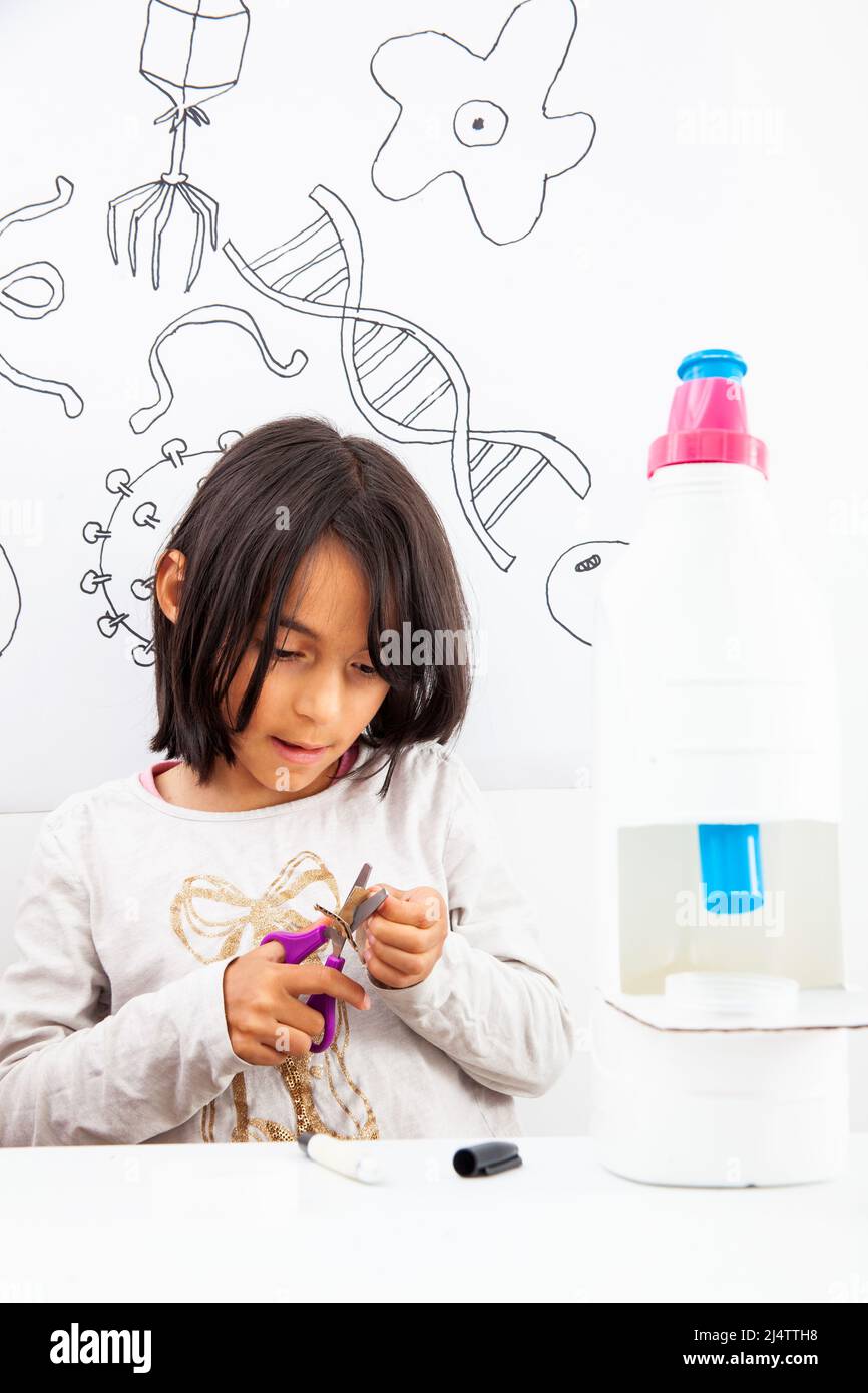 Young girl making a toy microscope with recyclable material Stock Photo ...