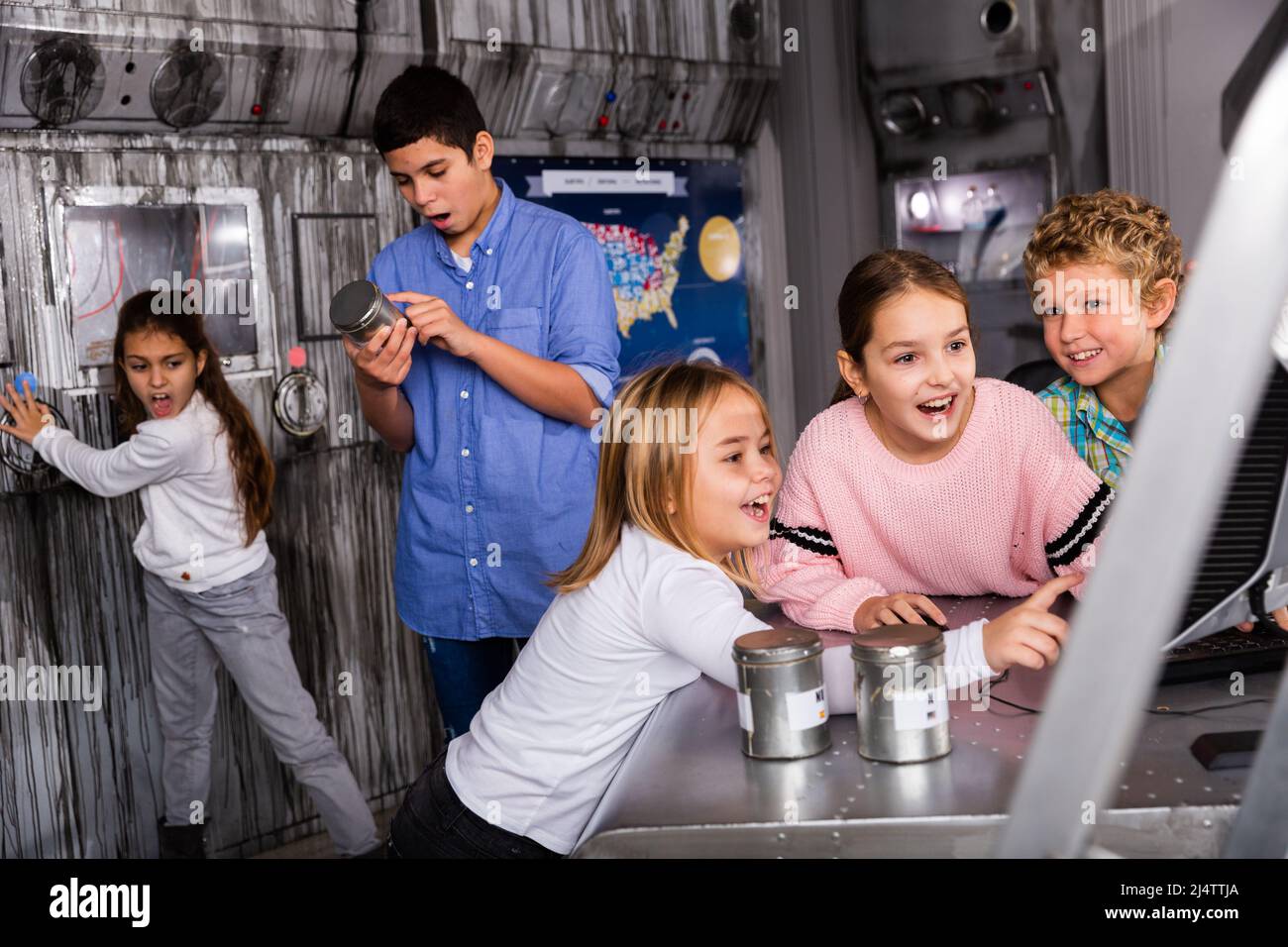 Tweenagers using computer to solve conundrum in lost room bunker Stock ...