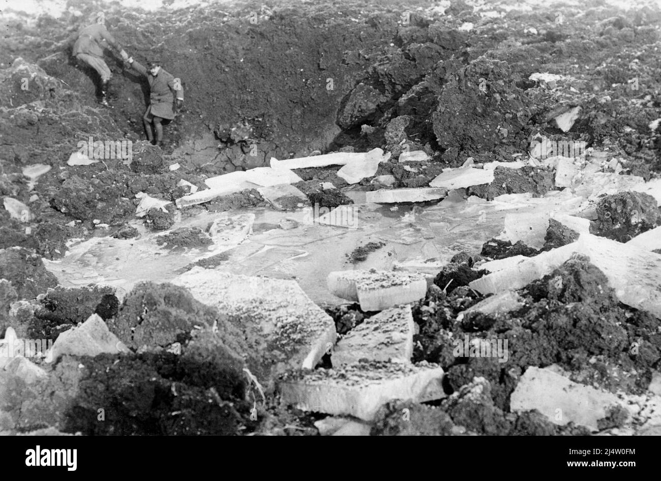 Two soldiers in a shell hole with thick ice at the bottom Stock Photo ...