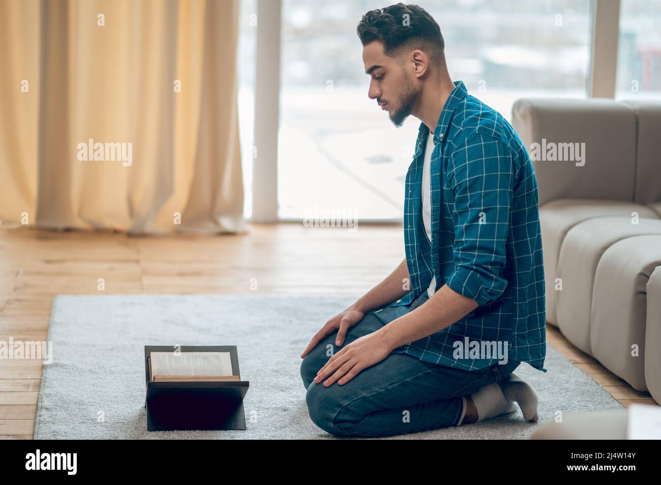Young muslim praying at home and looking concentrated Stock Photo - Alamy