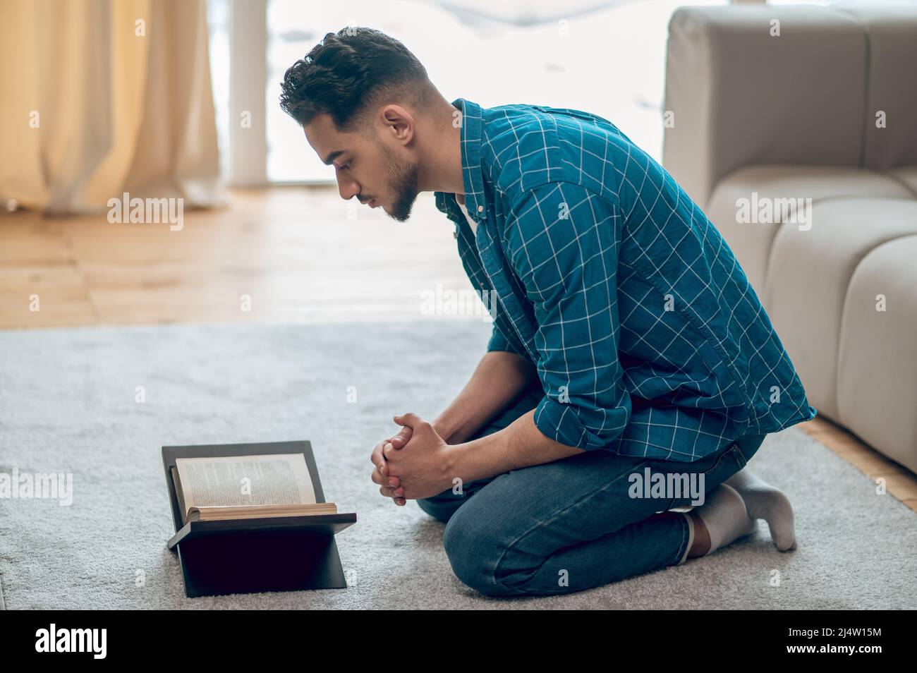 Young muslim praying at home and reading Quran Stock Photo - Alamy