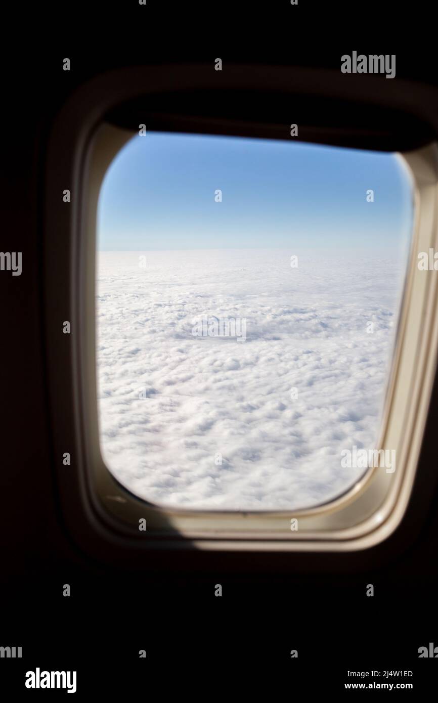 Airplane flight. Wing of an airplane flying above the clouds. View from the window of the plane ...
