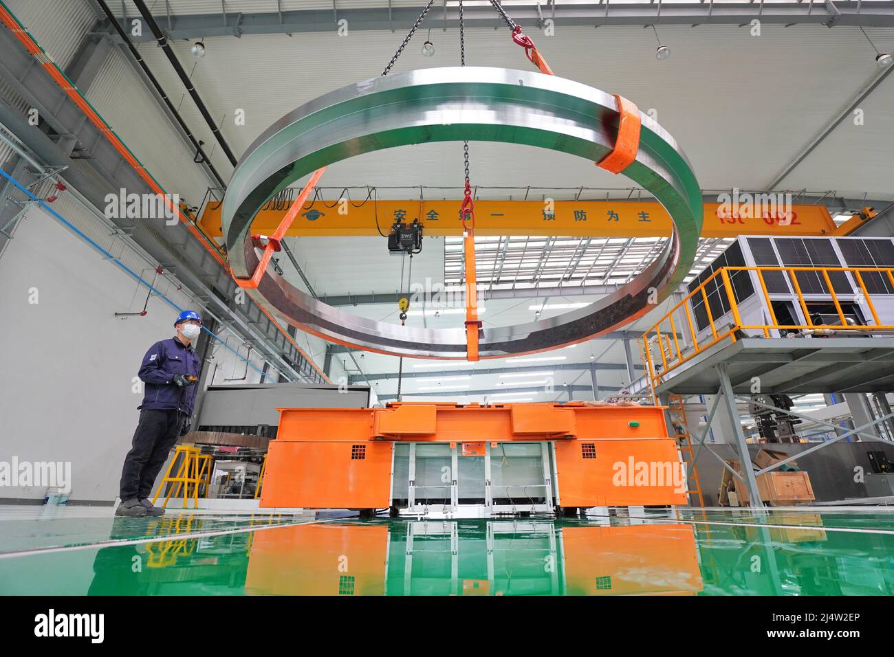 YANTAI, CHINA - APRIL 18, 2022 - A worker lifts a wind turbine bearing ...