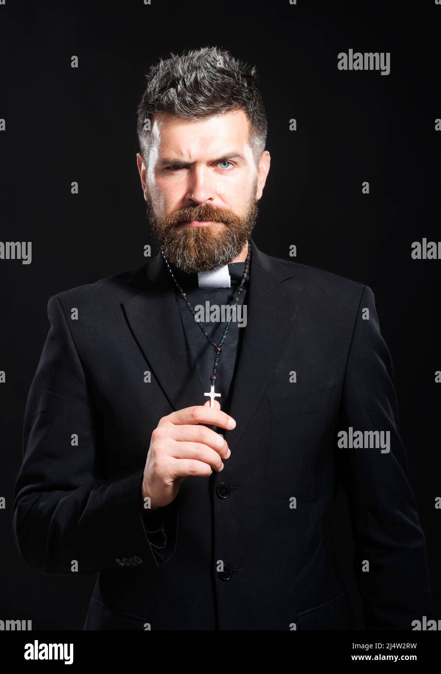 Religion concept. Handsome hispanic catholic priest man over black ...