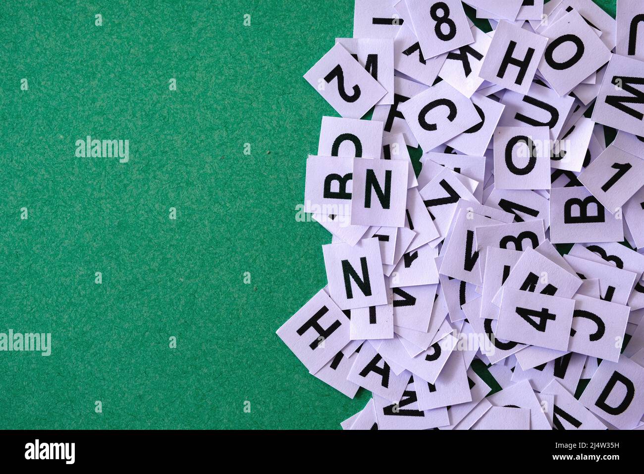 Paper with letters and numbers on green background with copy space as ...